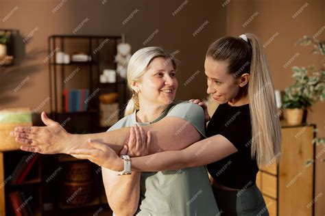 Premium Photo Young Caregiver Assisting Middle Aged Woman Doing