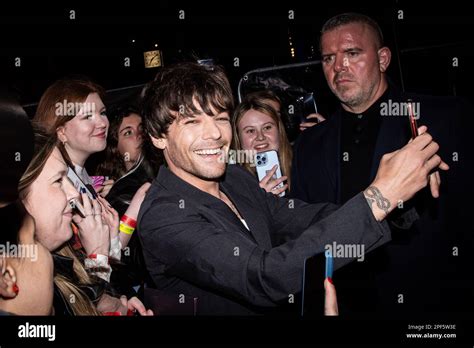Louis Tomlinson Poses For Selfies With Fans Upon Arrival At The