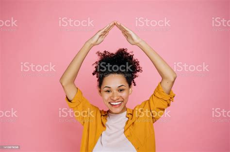 Happy Curly Haired African American Girl Making Roof Of Hands Above