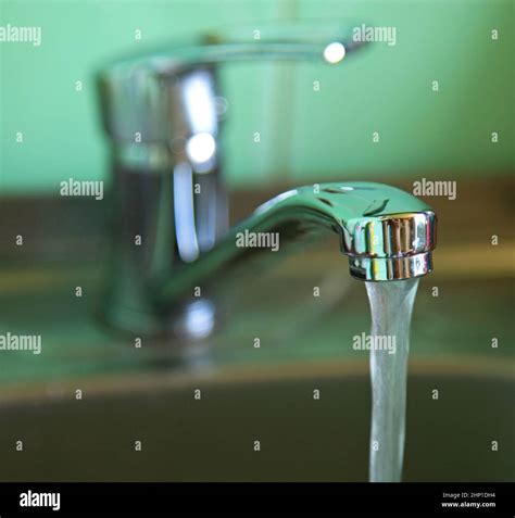 Water Flows From The Tap Faucet With Water That Flows Into The Kitchen