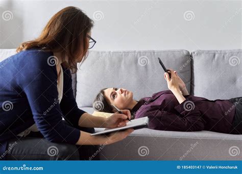 Young Woman At Consultation With Psychologist Female Patient Lying On