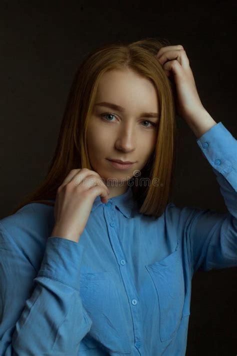 Portrait Of Girl Young Woman With Long Blonde Hair Wearing A Blue Shirt
