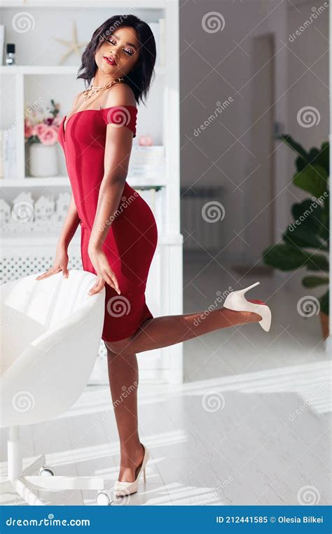 Linda Mulher De Vestido Vermelho E Salto Alto No Quarto Iluminado Pelo