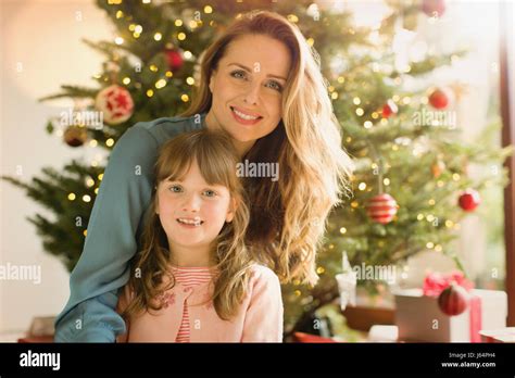 Portrait Smiling Mother And Daughter In Front Of Christmas Tree Stock
