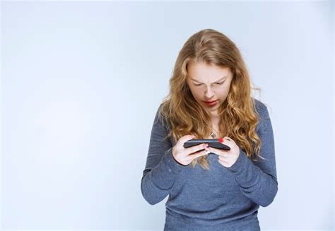Chica Enviando Mensajes De Texto Con Amigos Y Parece Confundida Foto
