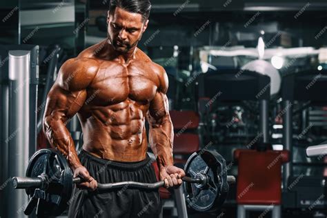 Premium Photo Body Builder Doing Barbell Bicep Curls At The Gym