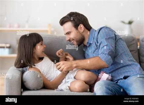 Happy Daddy And Cute Daughter Play Together Tickling On Sofa Stock