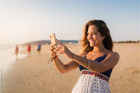 Young Woman Taking A Selfie At The Beach By Stocksy Contributor