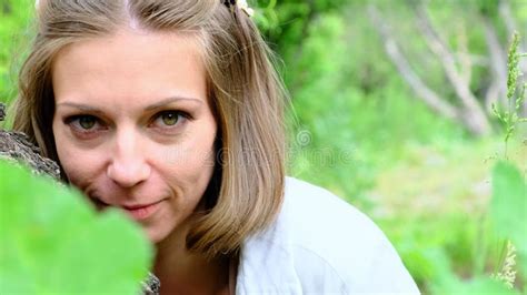 A Mysterious Middle Aged Beautiful Woman Peeks Out From Behind A Tree