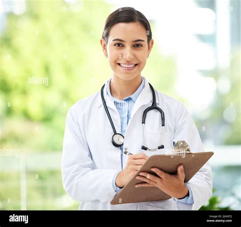 Confident Young Mixed Race Female Doctor Standing With Clipboard A
