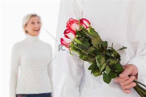男人向年长的女人藏着一束玫瑰高清摄影大图 千库网