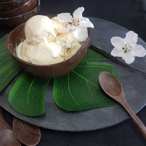 A Bowl Filled With Ice Cream Sitting On Top Of A Green Leaf Covered
