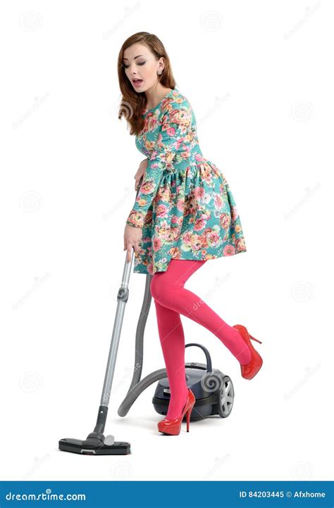 Young Woman In Dress Using Vacuum Cleaner On White Background Stock