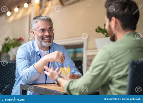 Two Men Sitting In The Cafe And Having An Interesting Conversation