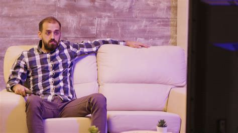 Caucasian Bearded Man Sitting On Sofa While Watching Tv Shows Man