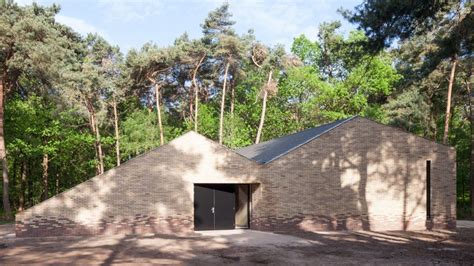 angular brick clad theatre by reset architecture sits in a woodland
