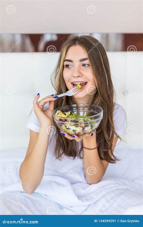 Young Beautiful Woman Vegetarian Eating Fresh Green Salad At Home Stock