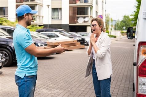 Premium Photo Delivery Man Wearing Blue Uniform Delivers Pizza To A