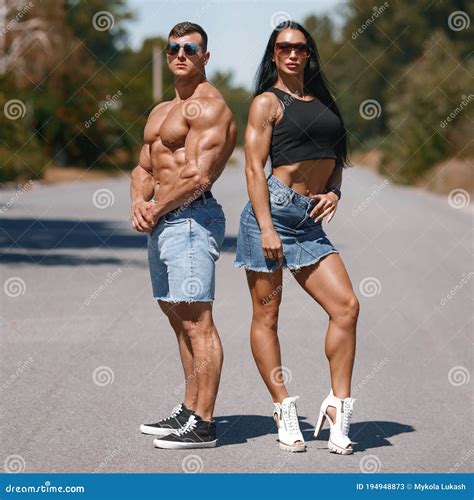 Muscular Couple Outdoors Sporty Man And Woman Showing Muscles Stock