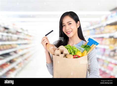 Beautiful Asian Woman Holding Paper Bag Full Of Groceries Shopping With