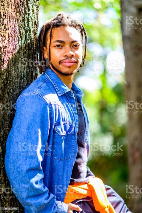 Handsome Young Black Man With Dreads Smiles In A Candid Headshot
