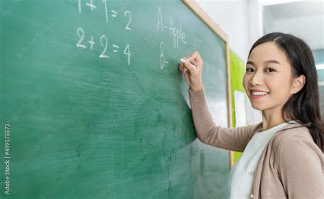 Closeup Portrait Of Young Happy Asian Teacher Write On Chalk Board