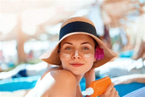 Young Woman In Bikini Holding Bottles Of Sunscreen In Her Hands