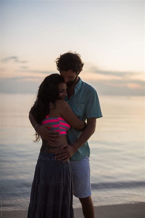 «young Couple Hugging At The Beach At Sunset Del Colaborador De