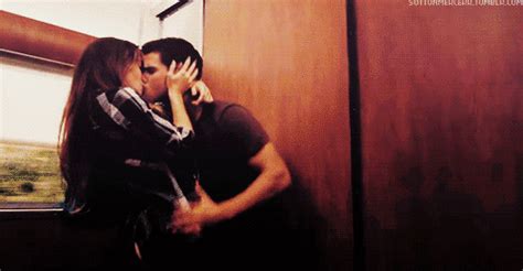 A Man And Woman Kissing In Front Of A Window
