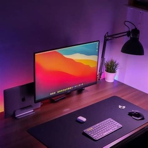 a computer monitor sitting on top of a wooden desk next to a keyboard ...