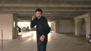 Close up view of man in black with a knife attacking toward the camera. Man slashing and stabbing with a knife. Knife fighting. Point of view.