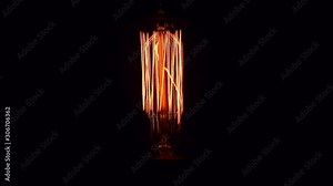 Clear glass electric lightbulb dimmed to enable it's tungsten filament to be seen