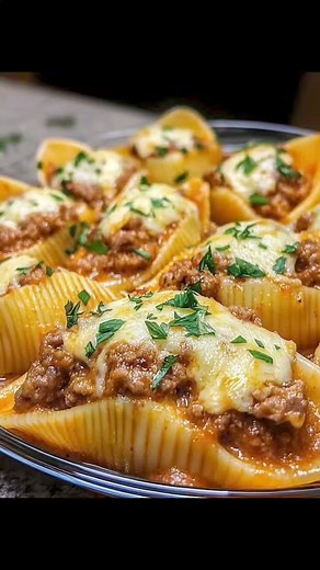 Creamy Ricotta Beef Stuffed Shells Pasta Ingredients: 20 large pasta shells 1 lb lean ground beef 1 cup ricotta cheese 1 ½ cups shredded mozzarella cheese, divided ½ cup grated Romano cheese 1 large egg, beaten 2 ½ cups tomato basil sauce 1 tsp dried oregano 2 cloves garlic, minced Salt and black pepper, to taste Fresh parsley, chopped (for garnish) Instructions: Preheat Oven: Heat your oven to 375°F (190°C). Cook Pasta: Boil pasta shells in salted water until al dente. Drain and set aside. Prep