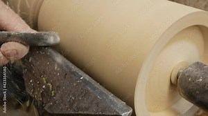 close-up hands of professional carpenter. man carpenter using skew chisel for shaping piece of wood on wood turning lathe at workshop. 4k video