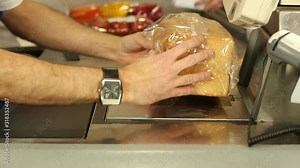 Scanning Groceries barcodes at the Cash register in the supermarket. The checkout assistant scans the food items. Close up