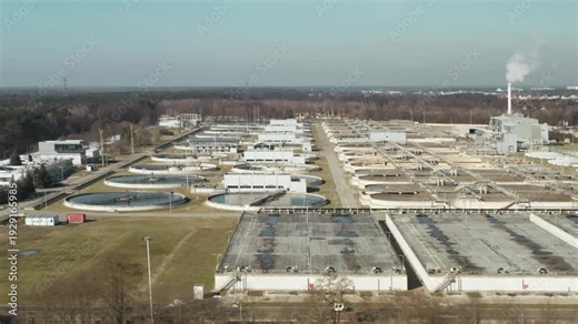 Extensive infrastructure of aeration basins processes liquid waste using active sludge technology to remove biological hazards and purify water at large industrial utility complex.