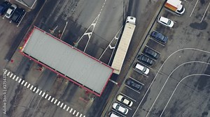 Aerial Shot of Industrial Warehouse Loading Dock where Many Truck with Semi Trailers Load Merchandise.