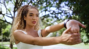 Active Woman Engaging in Hand Flexibility Exercises Outdoors, Energetic Female Athlete Performing Wrist Stretches in Nature