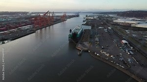Cinematic aerial drone shot of the Port of Tacoma, Washington United Terminal, container cranes, harbor, piers, Commencement Bay, Puget Sound, Tacoma, near Seattle, an economic hub of Pierce County