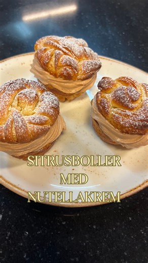 Et morsomt alternativ til fastelavnsboller 🍋 I dag viser Espen hvordan du lager sitrusboller med nutellakrem. En ny og annerledes versjon av fastelavnsbolle med en egen twist. Sitrusboller med nutellakrem: Sett en bolledeig og hev til dobbel størrelse. Se Espen sin versjon i video fra tidligere i uken. Kjevle deigen ut til et rektangel, ca. 0,5 cm tykt. Smør sitrussmør på 2/3 av deigen, brett sammen i tre lag og kjevle forsiktig ut i bredden. Skjær strimler på ca. 60–70 gram, tvinn og knyt til 