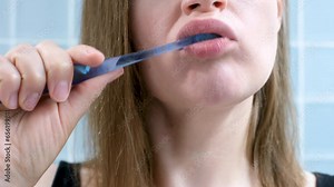 The girl brushes her teeth with toothbrush with toothpaste close-up, front view