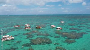 Fantastic view of boats in the open ocean with tourists swiming above coral reefs of Maracajau city near Natal in Rio Grande do Norte, Brazil
