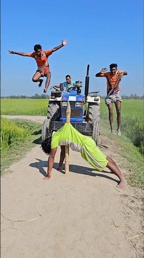 The man is lying in front of the tractor.