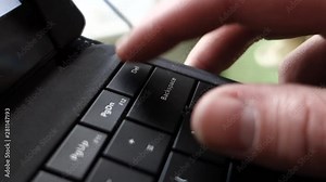 Finger pressing repeatedly, frantically on the Delete (DEL) key on a tablet keyboard.