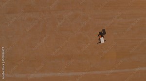 A traditional application in Turkey. A tractor is mixing bulgur wheat under the sun to make them dry equally. Tractor driver draws artictic shapes.