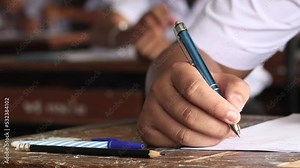 Students writing and reading exam answer sheets exercises in classroom of school with stress
