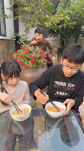 Anh dù sợ bố mắng, vẫn gắp cho em miếng xúc xích của mình.