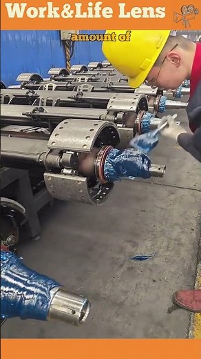 Operator manually applies grease to axle ends for protection, reducing friction and wear.