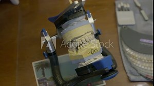 Dentistry prosthetic teeth model assembled at the stomatology laboratory. Dentistry prosthetic teeth held by orthodontology equipment. Manufacturing dentistry prosthetic teeth for treatment.