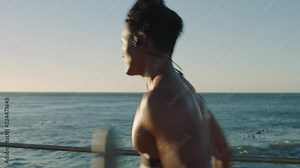 fit muscular young man running fast sprinting training intense cardio workout on beautiful ocean seaside sunset fitness lifestyle